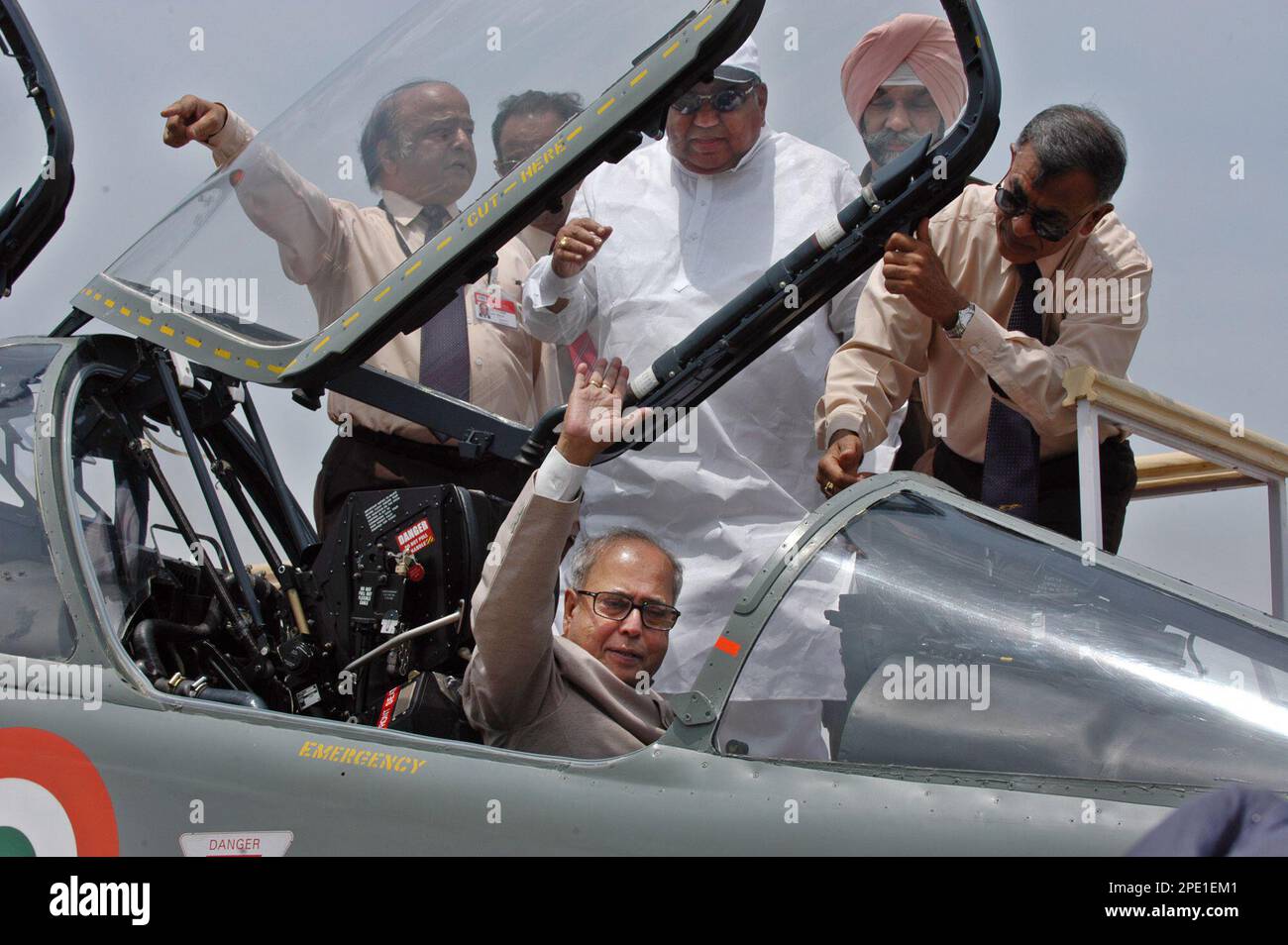 Indian Defense Minister Pranab Mukherjee waves from inside the cockpit ...