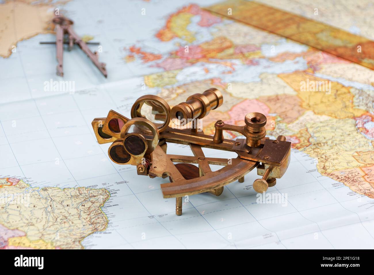 nautical sextant with optics, compass and ruler lying on paper world ...