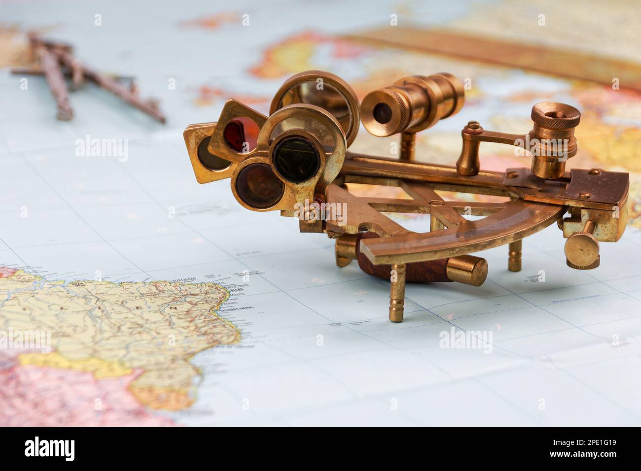 nautical sextant with optics, compass and ruler lying on paper world ...