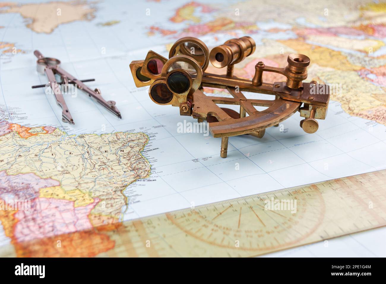 nautical sextant with optics, compass and ruler lying on paper world ...