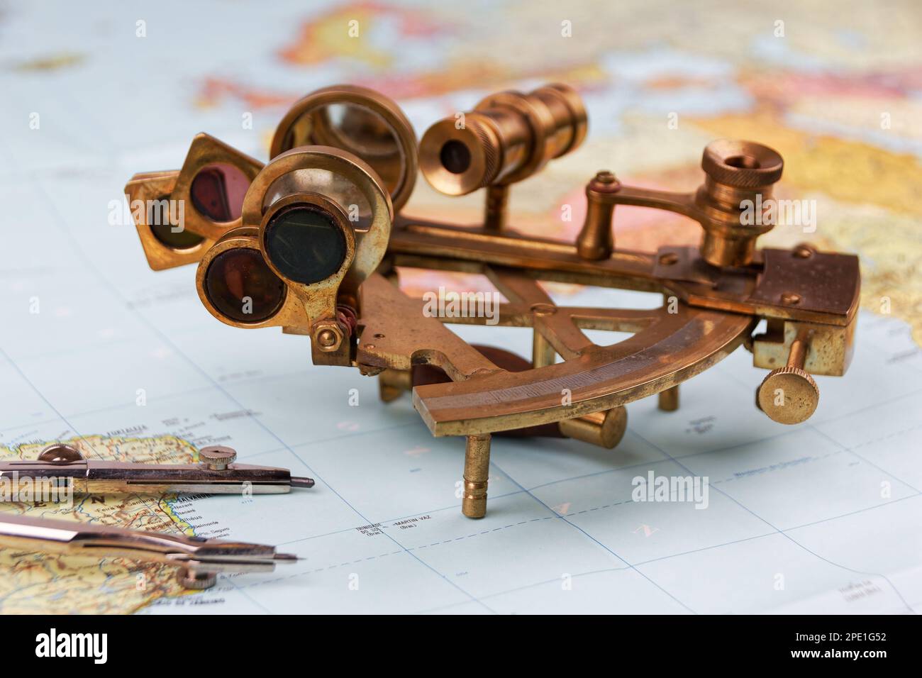 nautical sextant with optics, compass and ruler lying on paper world ...