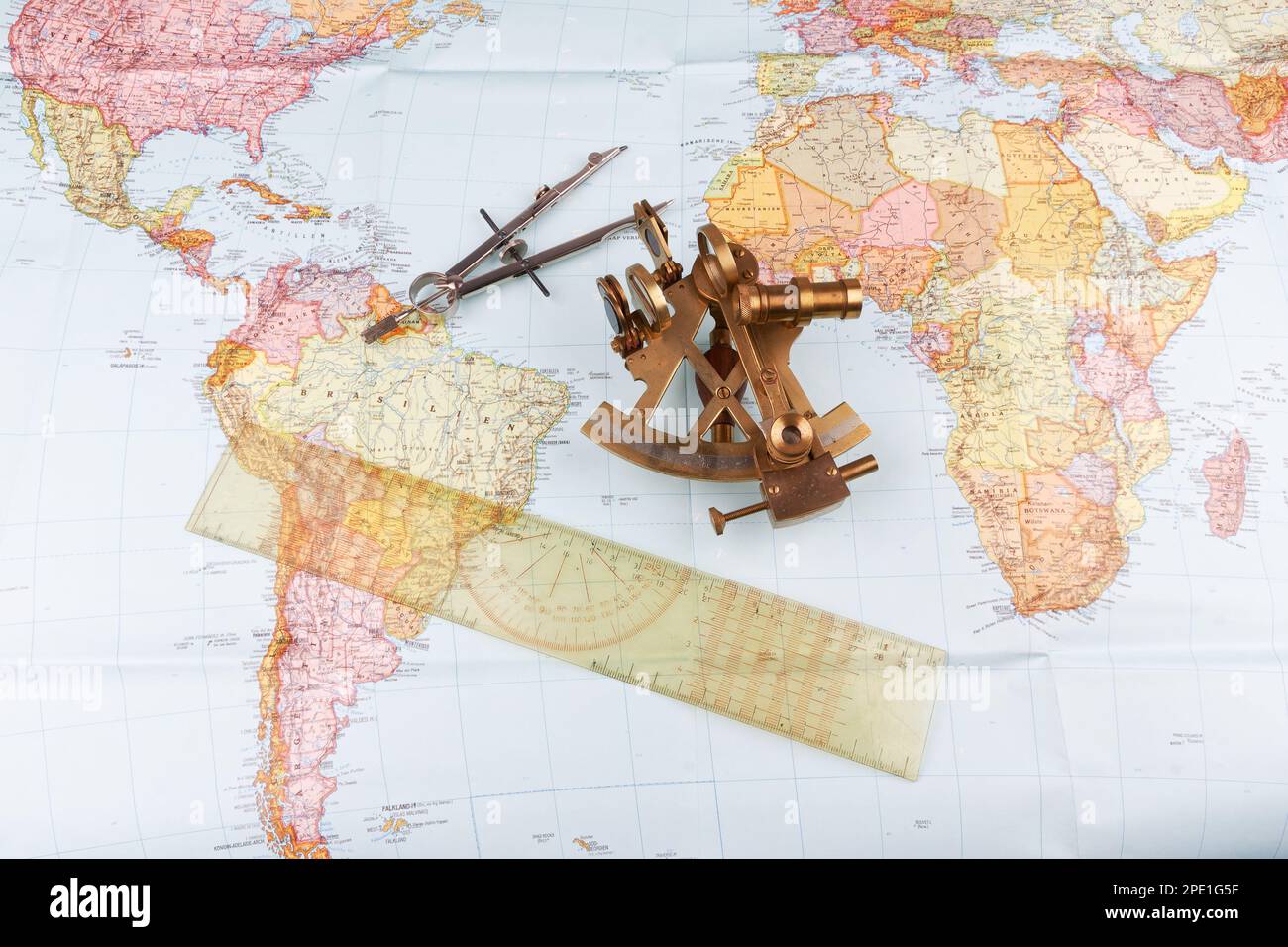 nautical sextant with optics, compass and ruler lying on paper world ...