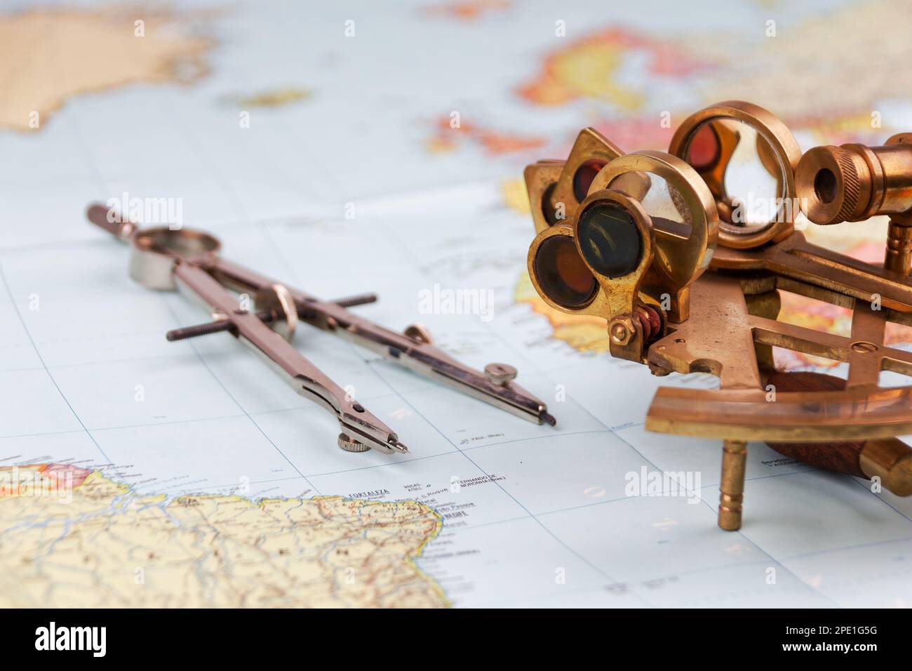 nautical sextant with optics, compass and ruler lying on paper world ...