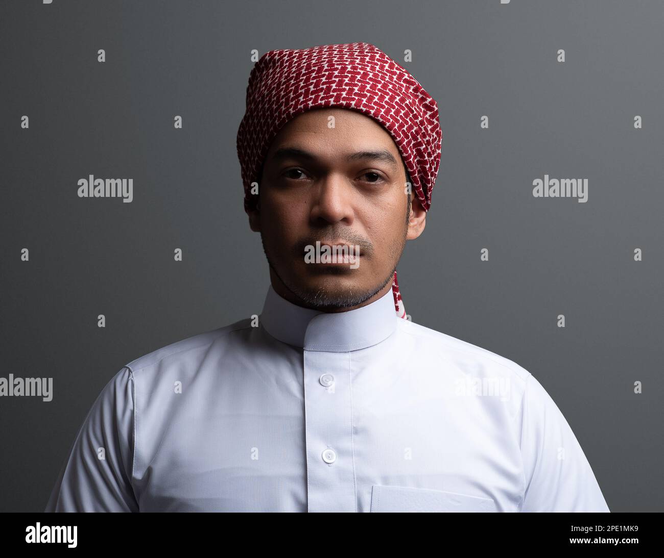 Muslim man wearing traditional clothing posing on black background ...