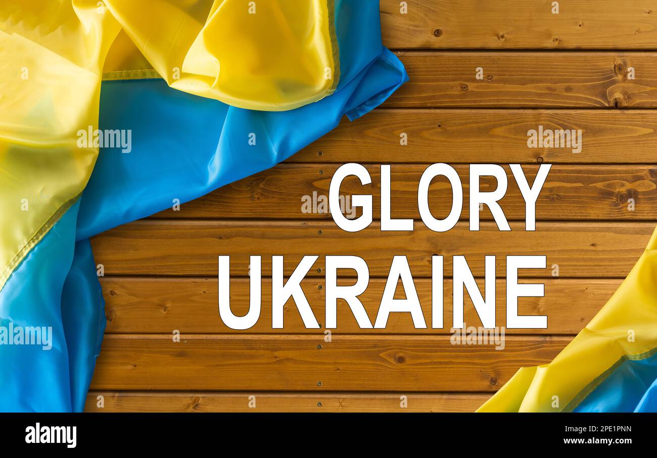 slogan Glory to Ukraine in Ukrainian on waved national flag Stock Photo ...