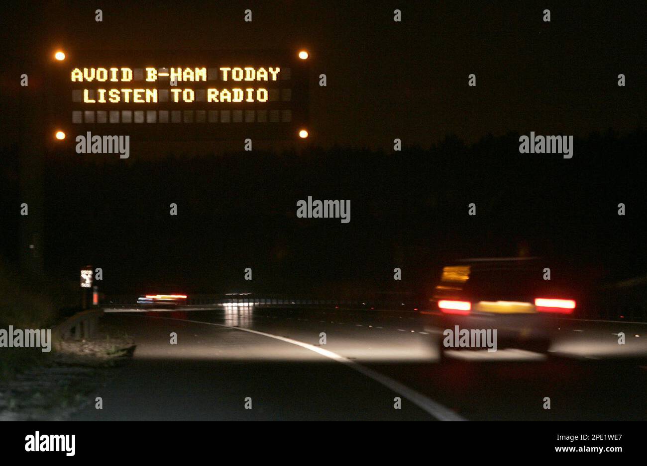 Cars pass a warning sign on the M40 motorway near Birmingham in England ...