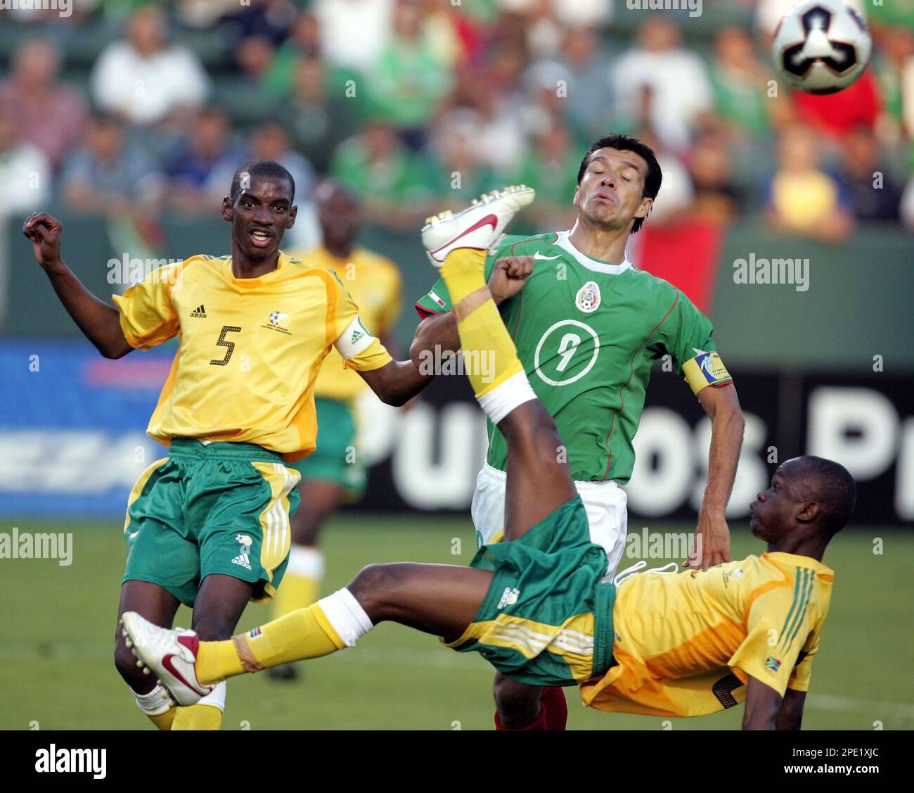South Africa's Siboniso Gaxa, right, kicks the ball past Mexico's Jared ...