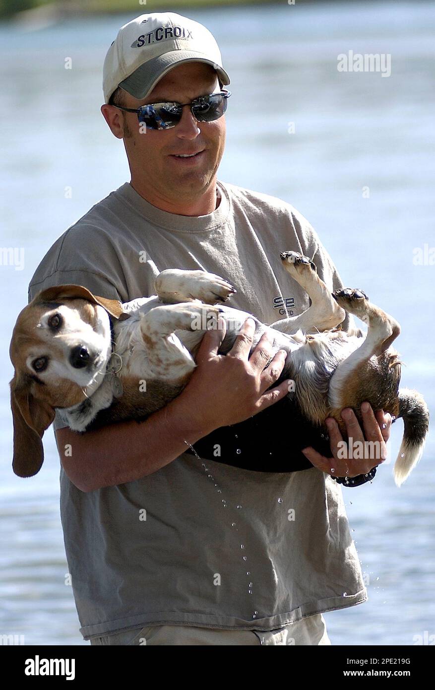 River guide Stirling Tyler scoops up his beagle Auggie from the ...
