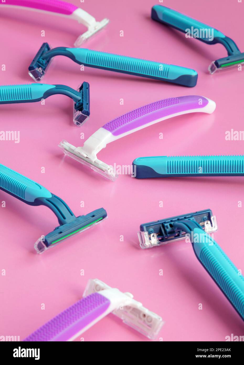 Many disposable purple and blue razors on a pink background. Colorful ...