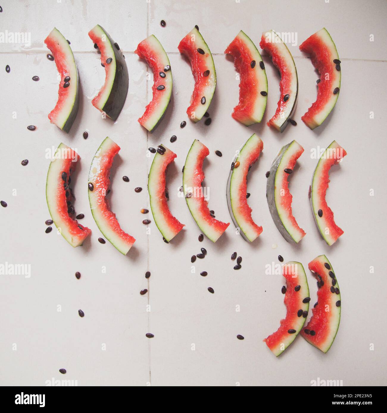 Group of watermelon rinds arranged in rows on a gray background ...