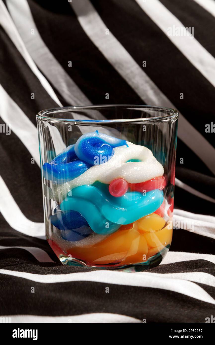 Various toothpaste of many colors squeezed into a glass. Delicious ...