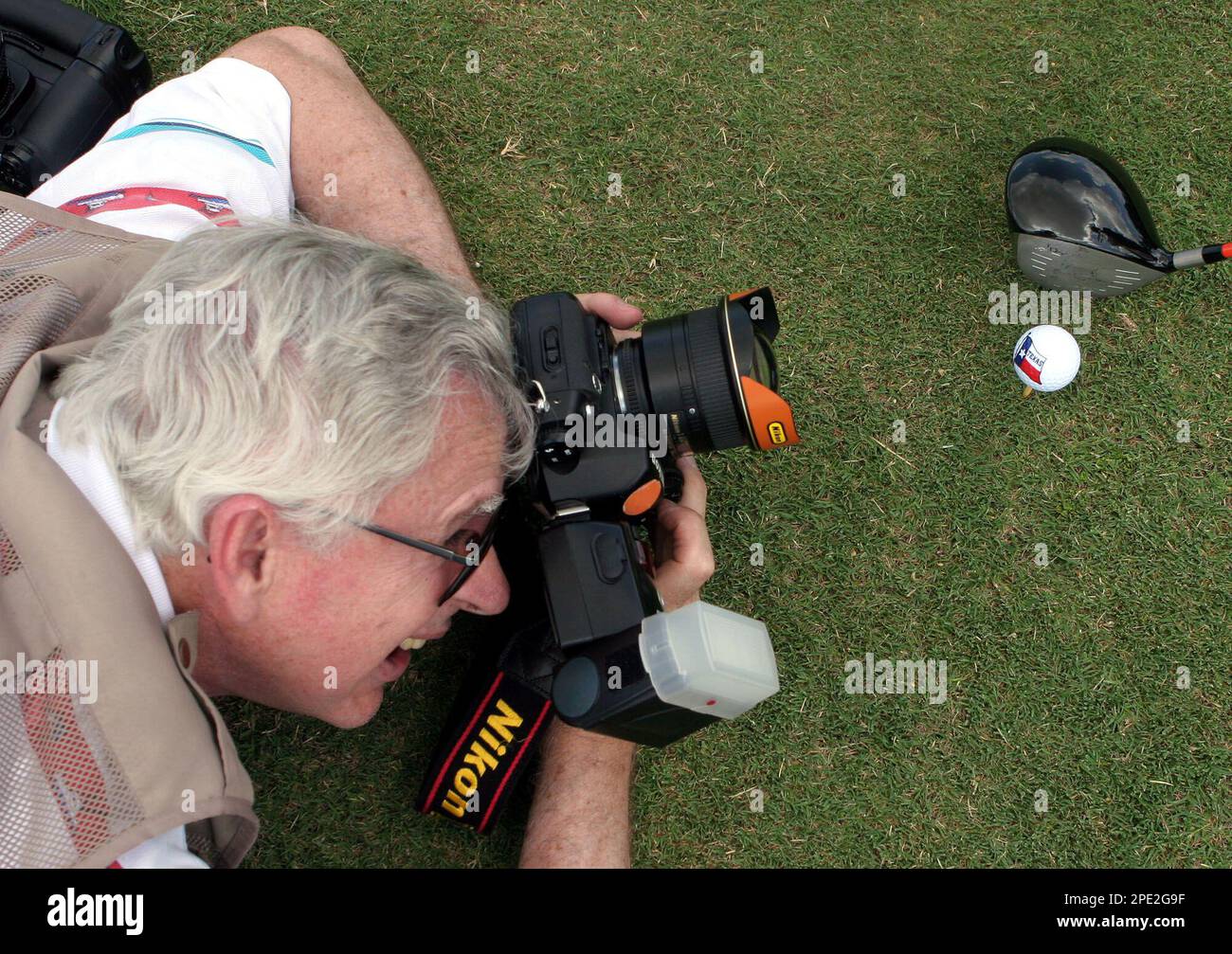 Photographer E. Joseph Deering, gets in close to photograph a golf ball ...