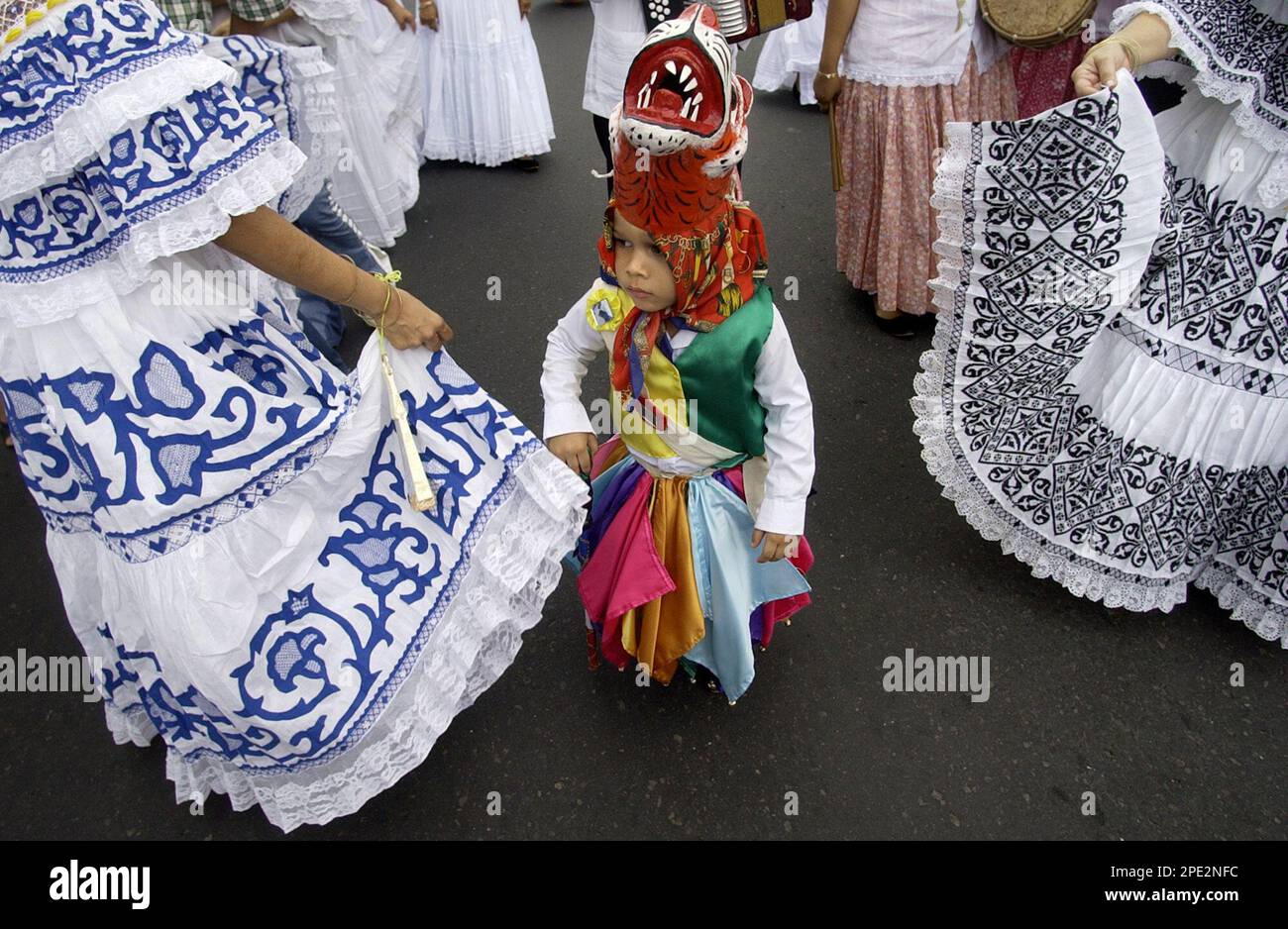 A boy with his devil mask dances between two women in Panamanian ...