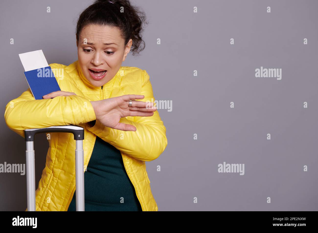 Anxious female passenger checking time on her wrist watch, expressing ...