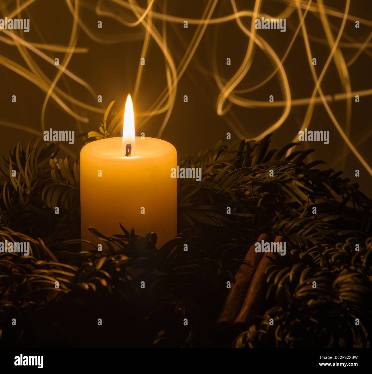 A glowing candle placed in front of decorated leaves, creating a ...
