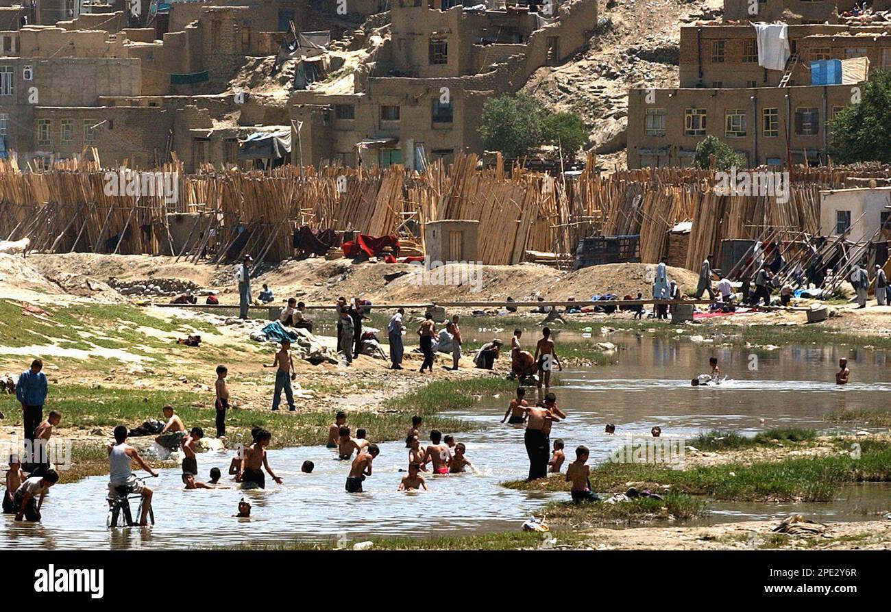 Afghan boys swim in the flooded water of Kabul river, Afghanistan on ...