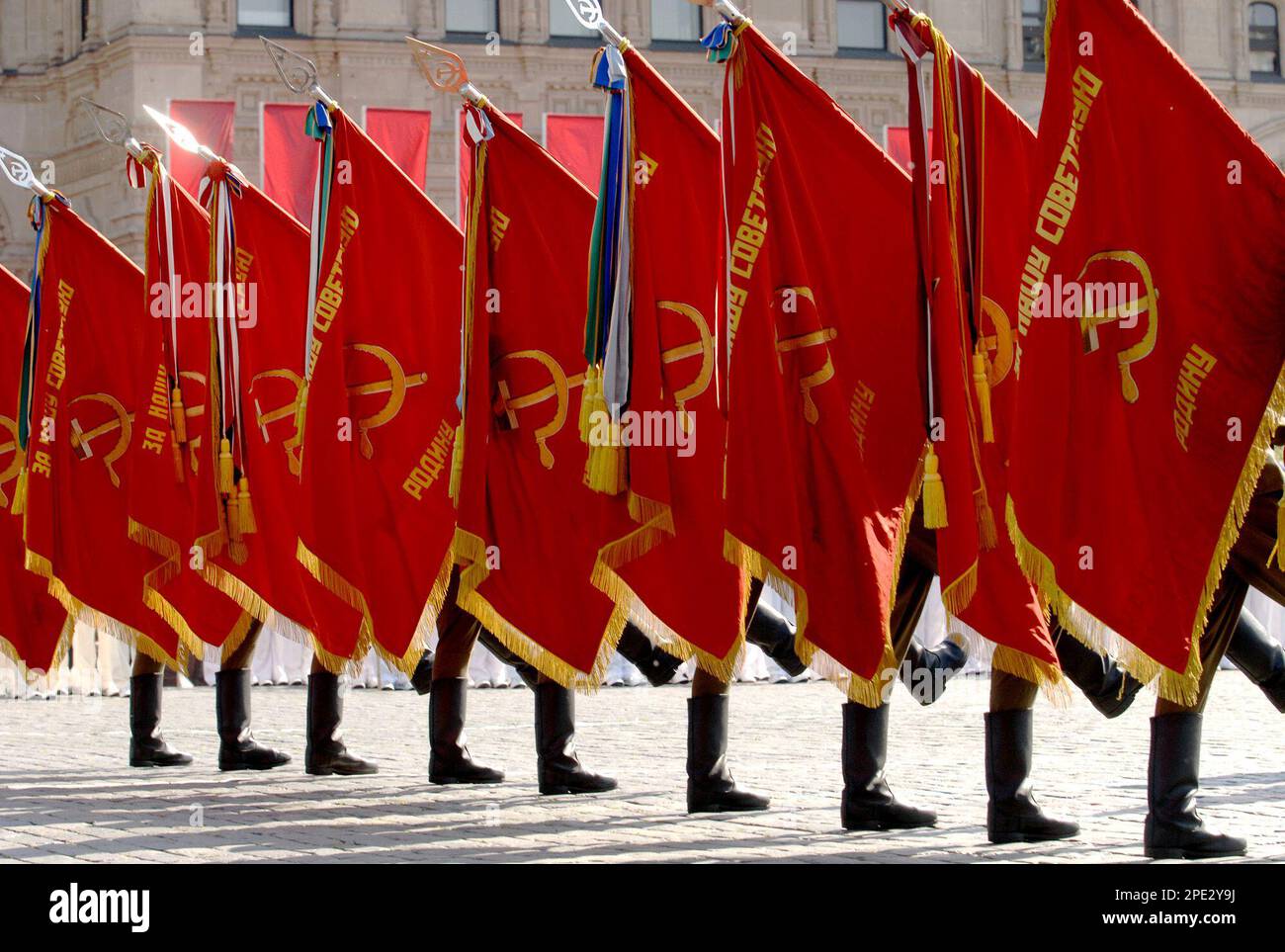 A line of young servicemen carrying banners march along Red Square to ...