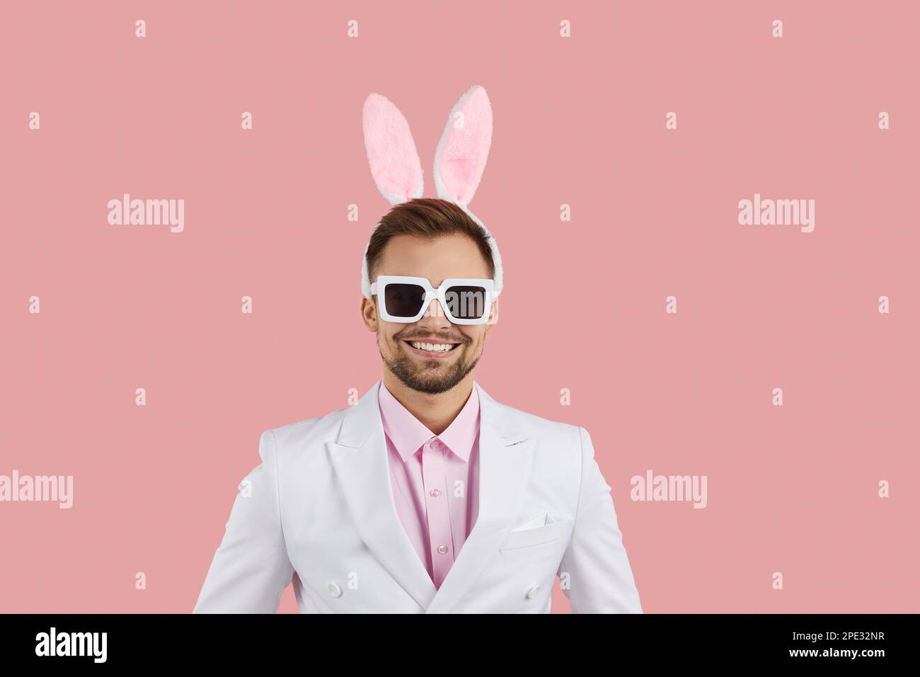 Young happy Caucasian man with funny bunny rabbit ears on head dressed ...