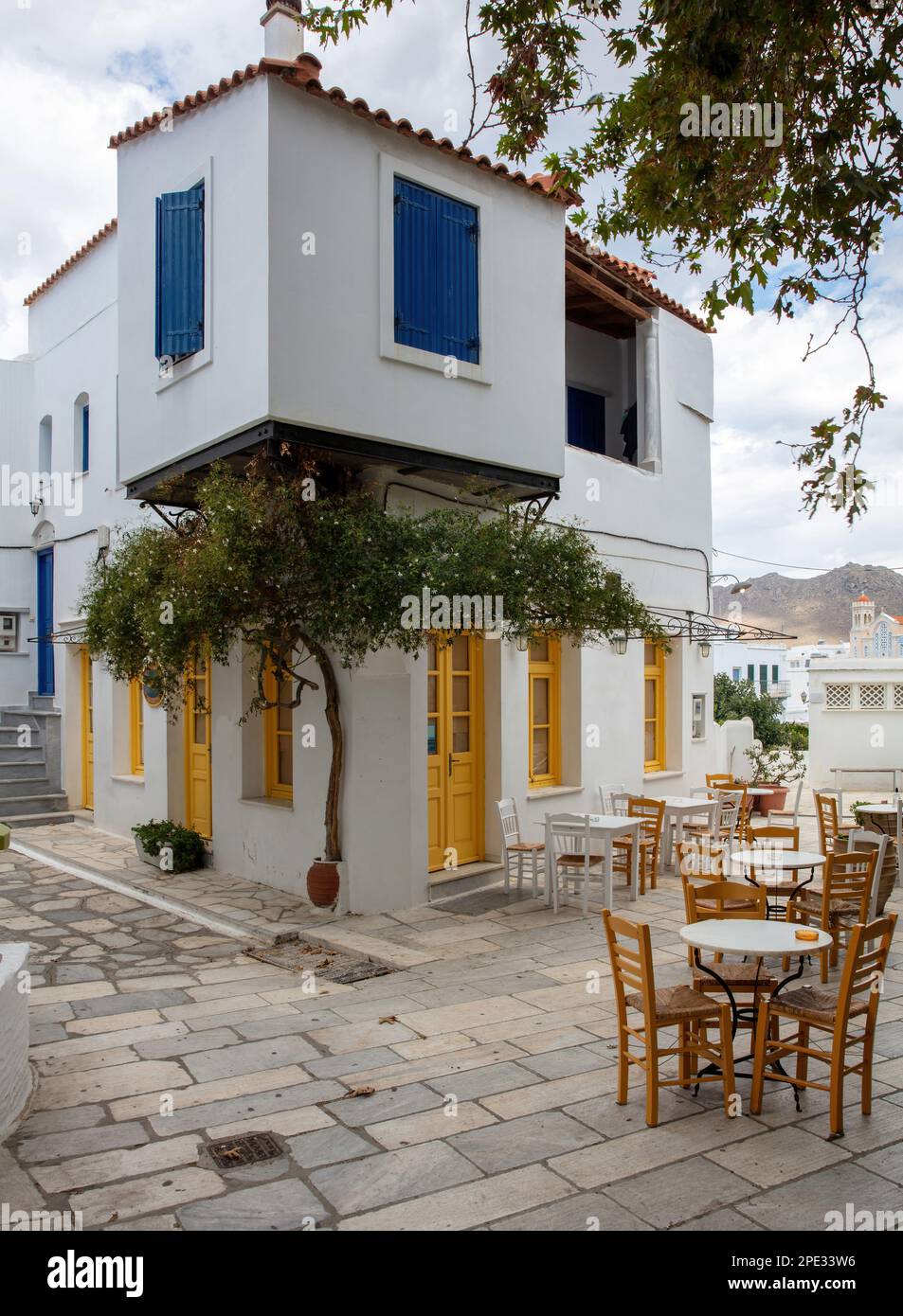 Greece. Tinos island Cyclades. Outdoors traditional cafe with yellow ...