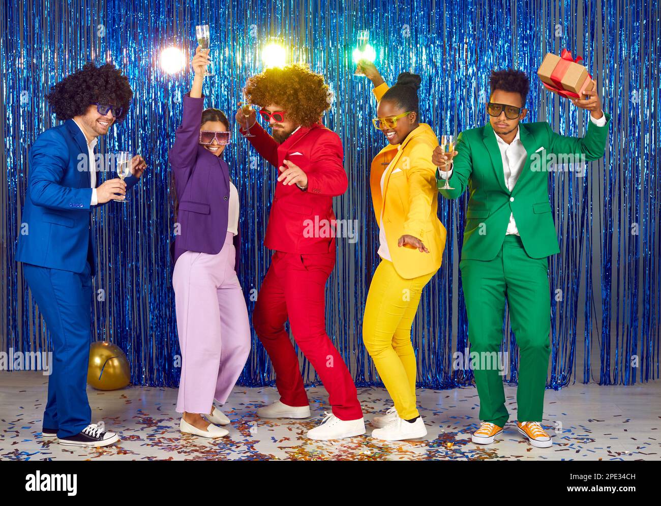 A modern dance group of five adult young people in multi-colored ...