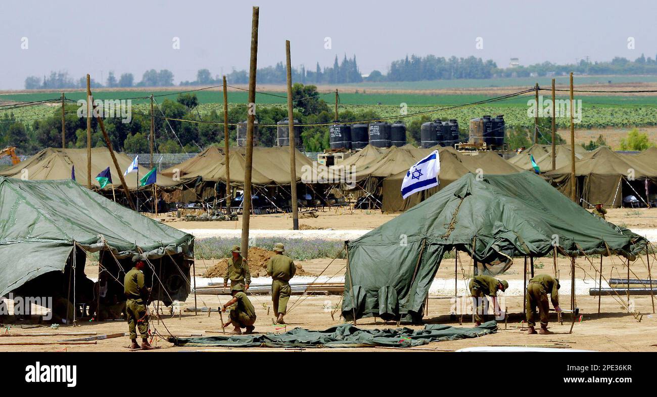 Israeli soldiers set up tents as they construct a new Israeli military ...