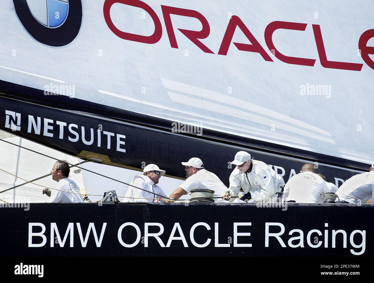 Crew members of the BMW Oracle racing Team yacht, from the US, maneuver ...