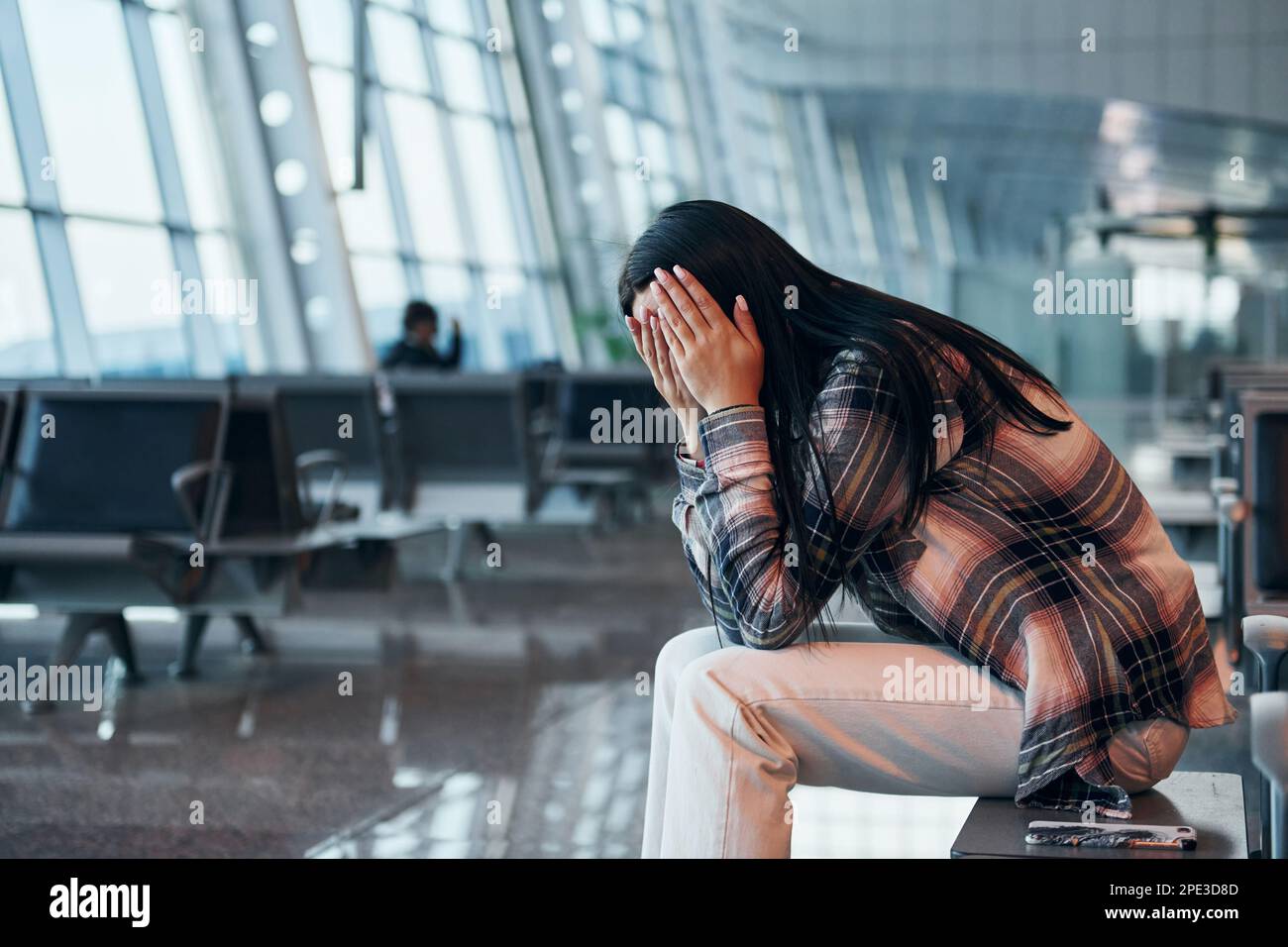 Sad young girl crying when sitting in the modern airport Stock Photo ...