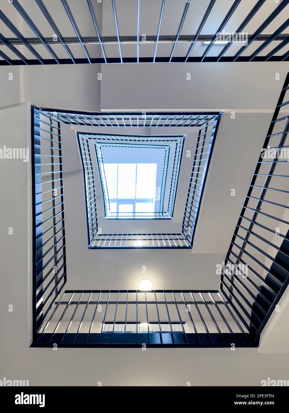 Bottom-up view of rectangular spiral staircase in modern multi-storey ...