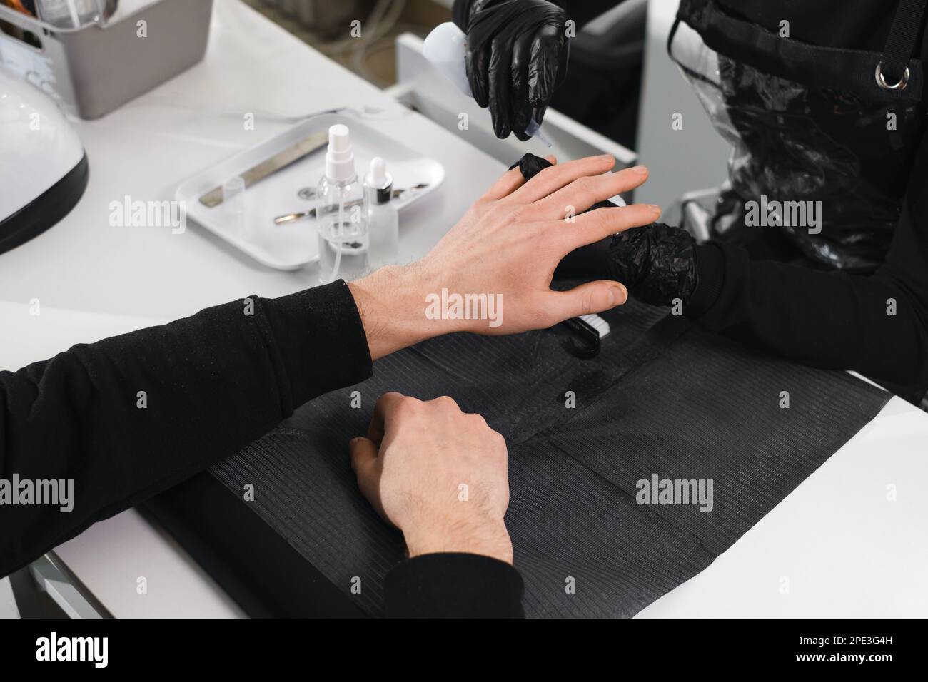 Male manicure. Close up view of the female nail service master doing ...