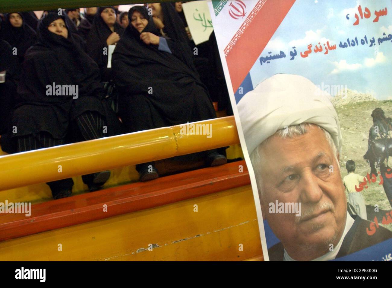 Behind a poster of him, Iranian women take part in a rally in Hejab ...