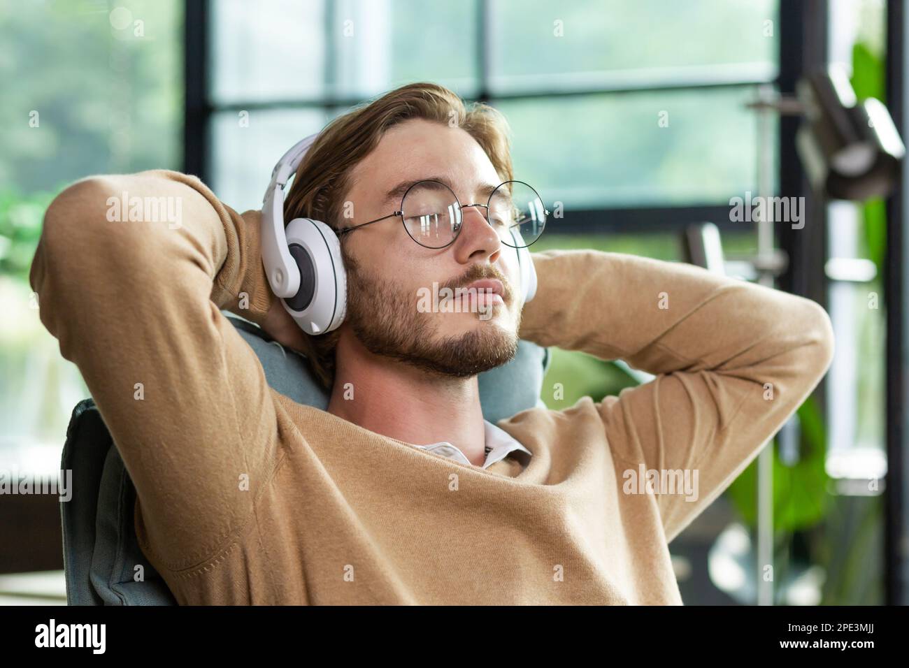 Creative programmer in headphones sits hi-res stock photography and ...