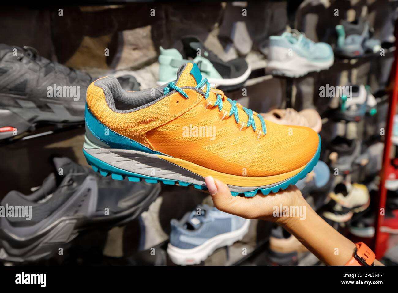 Girl choosing Sports comfortable shoes or sneakers on the store counter ...