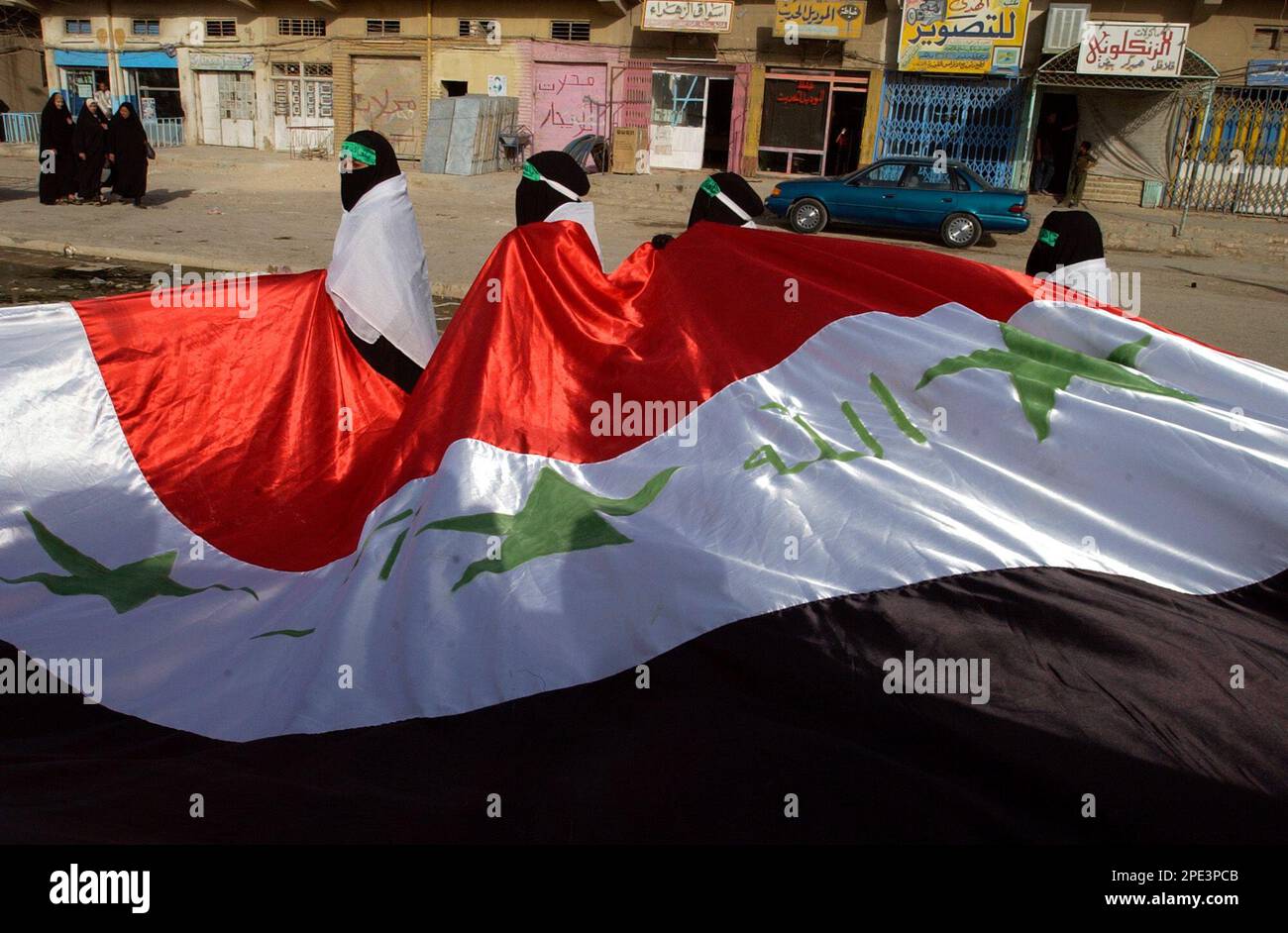 Followers of radical Shiite cleric Muqtada al-Sadr carry an Iraqi flag ...