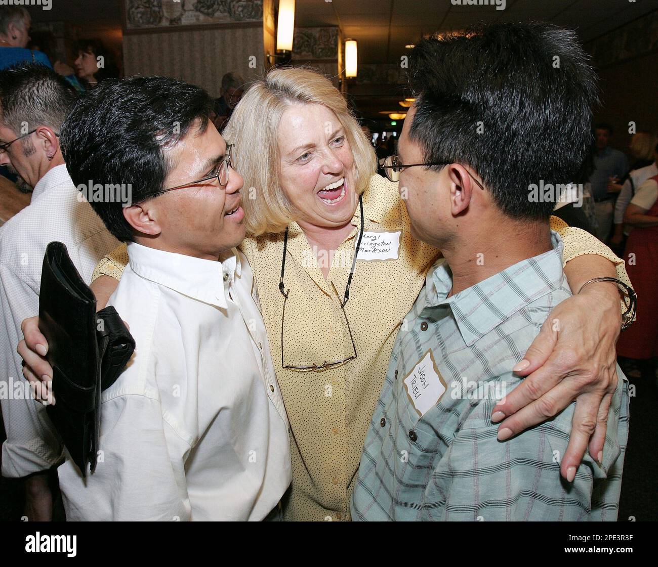 Cheryl Livingston Markson, center, hugs brothers Jason Triew, right ...