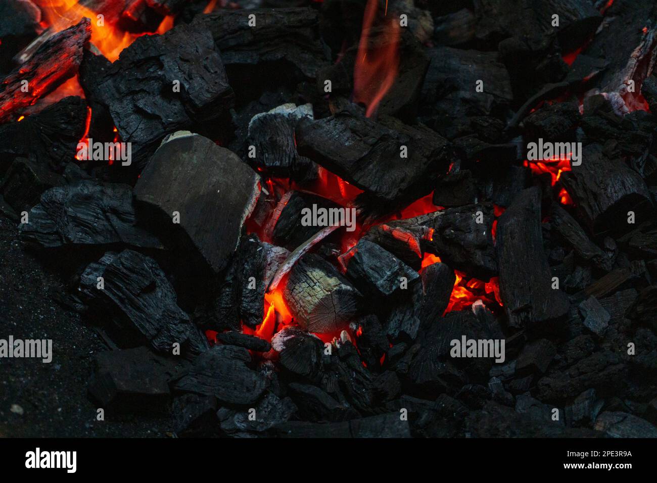 Coals with sparks in a huge old metal grill background Stock Photo - Alamy