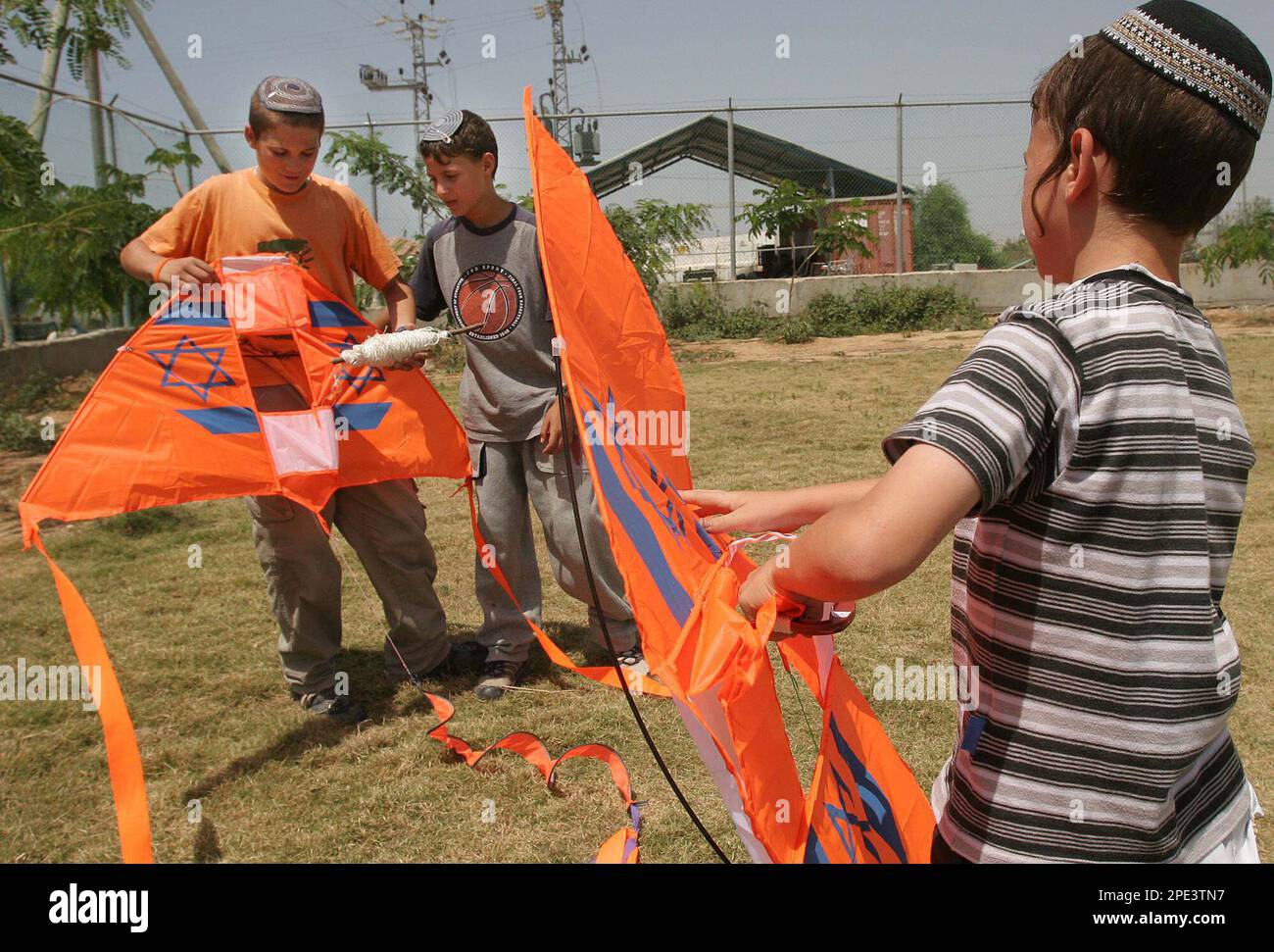 Jewish children prepare to fly orange kites, the color symbolizing the ...