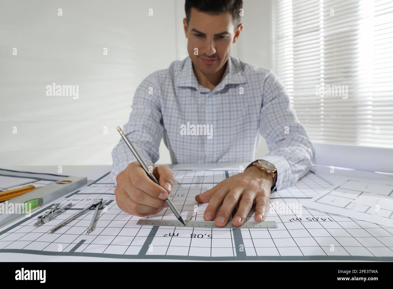 Architect working with construction drawings in office Stock Photo - Alamy