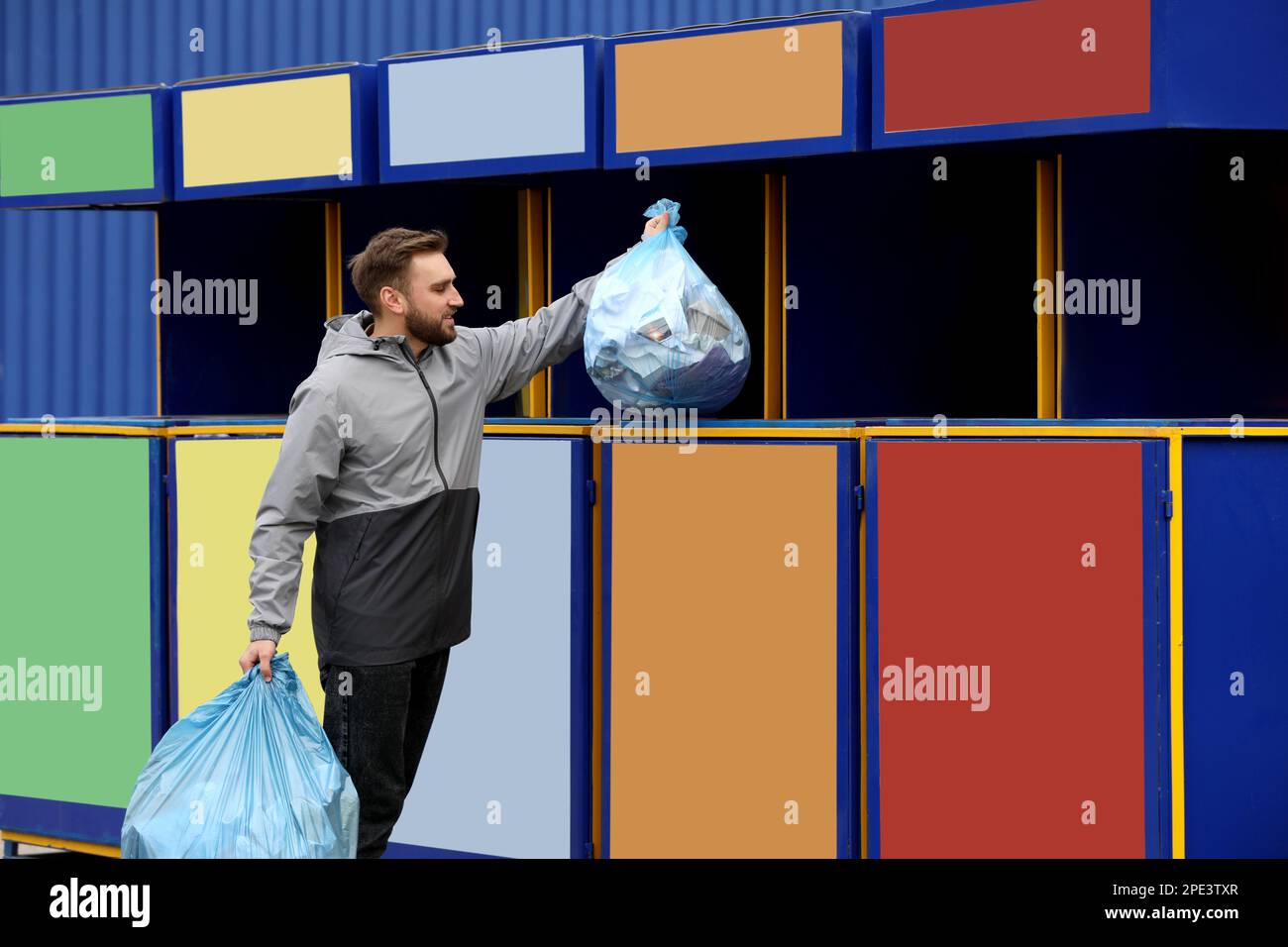 Man throwing garbage into bin at recycling point outdoors Stock Photo ...