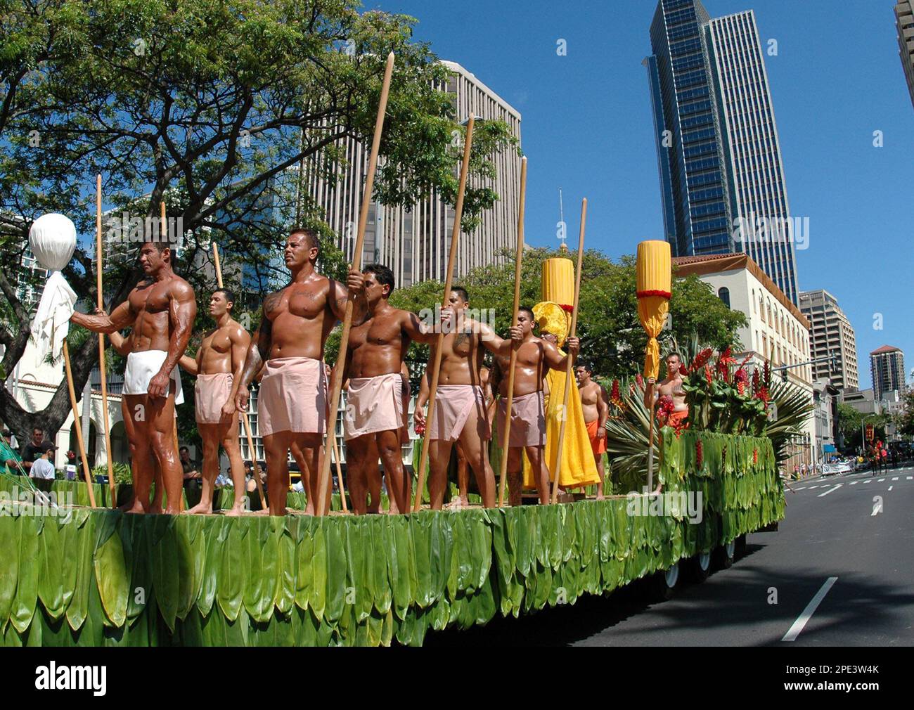 An all-male troupe, representing ancient Hawaiian warriors and their king, ride a float during ...