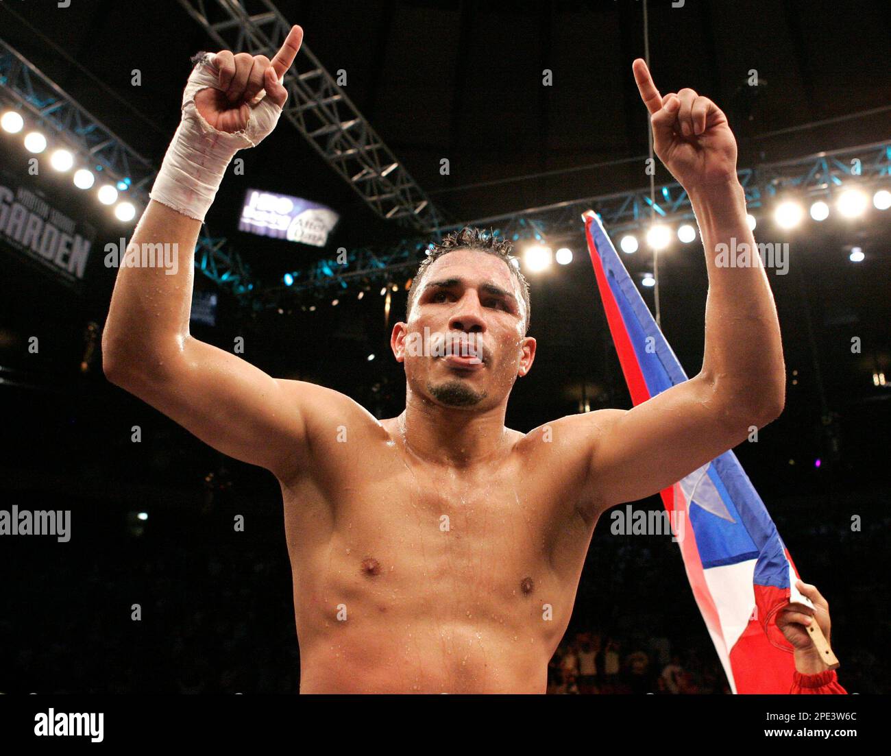 Miguel Cotto raises his hands after beating Muhammad Abdullaev to keep his WBO Super Lightweight ...