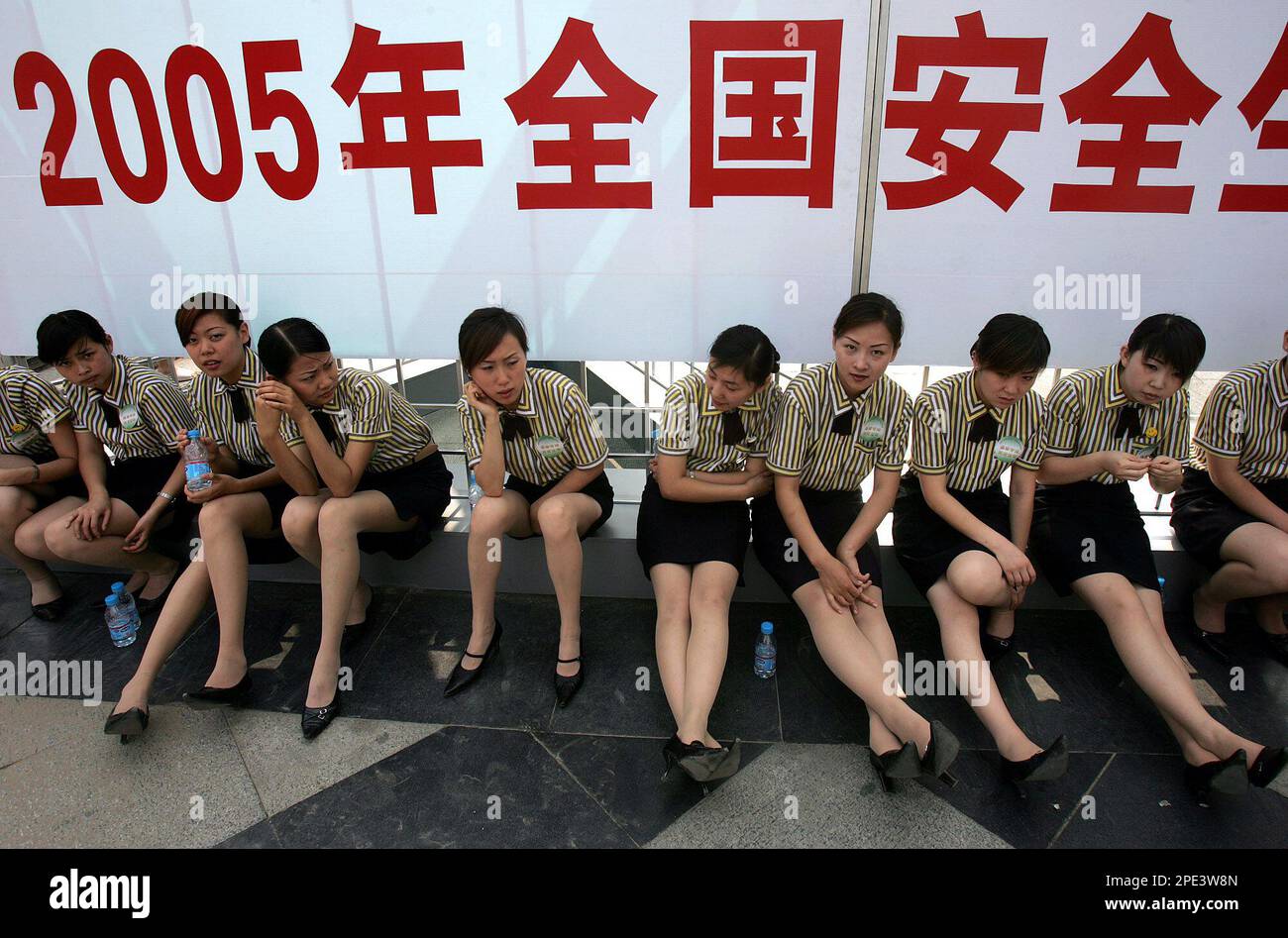 Female Chinese workers wait for the start of a work safety campaign ...