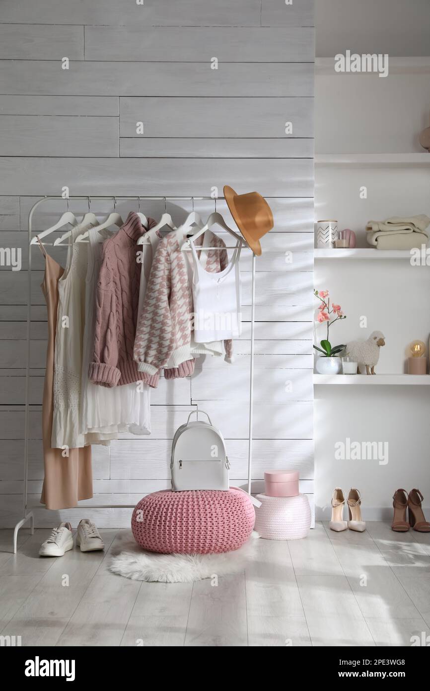Rack with different stylish clothes, shoes and decorative elements in ...