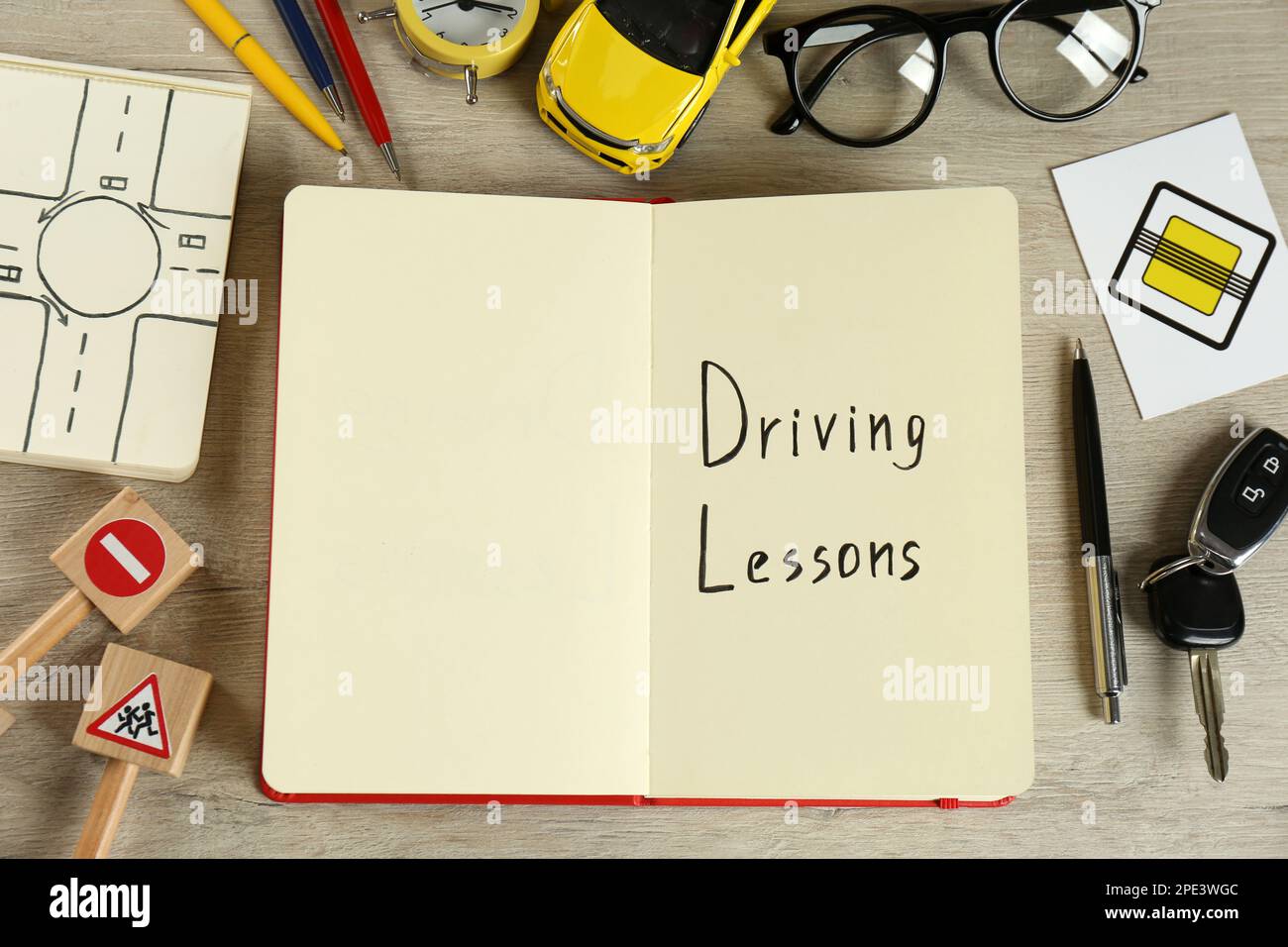 Flat lay composition with workbook for driving lessons on wooden ...