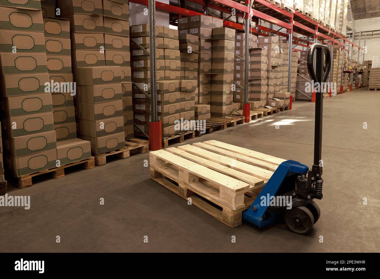 Modern manual forklift with wooden pallets in warehouse Stock Photo - Alamy