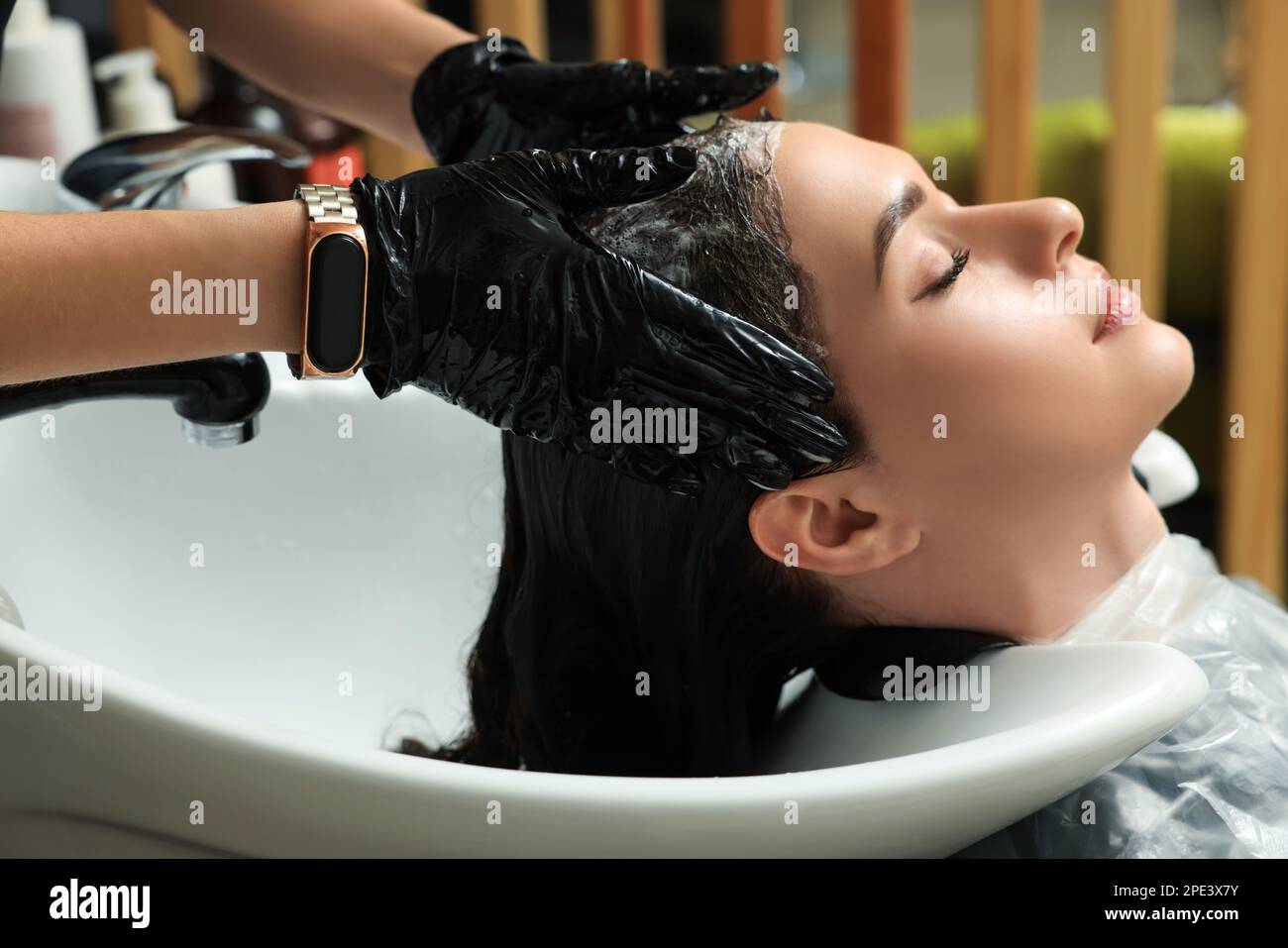 Hairdresser rinsing out dye from woman's hair in beauty salon Stock ...