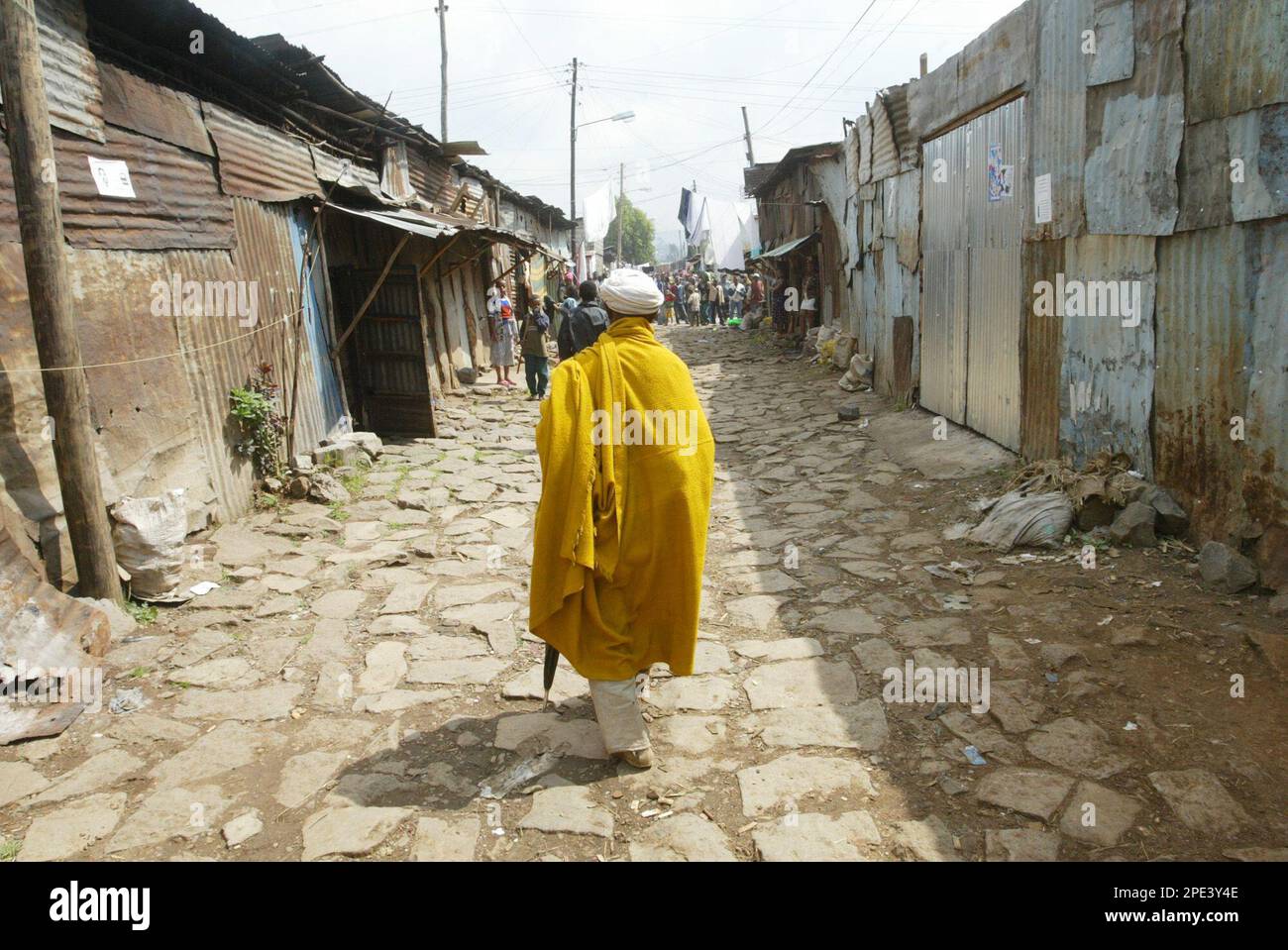 A religous man walk in a street in a poor area of Addis Ababa, the ...
