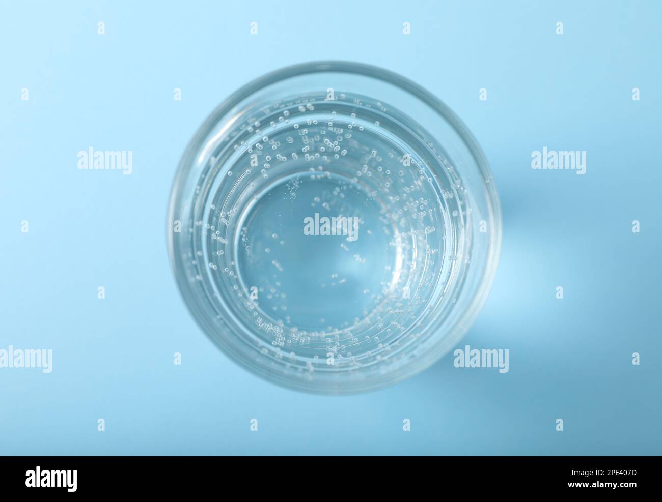 Glass of soda water on light blue background, top view Stock Photo - Alamy