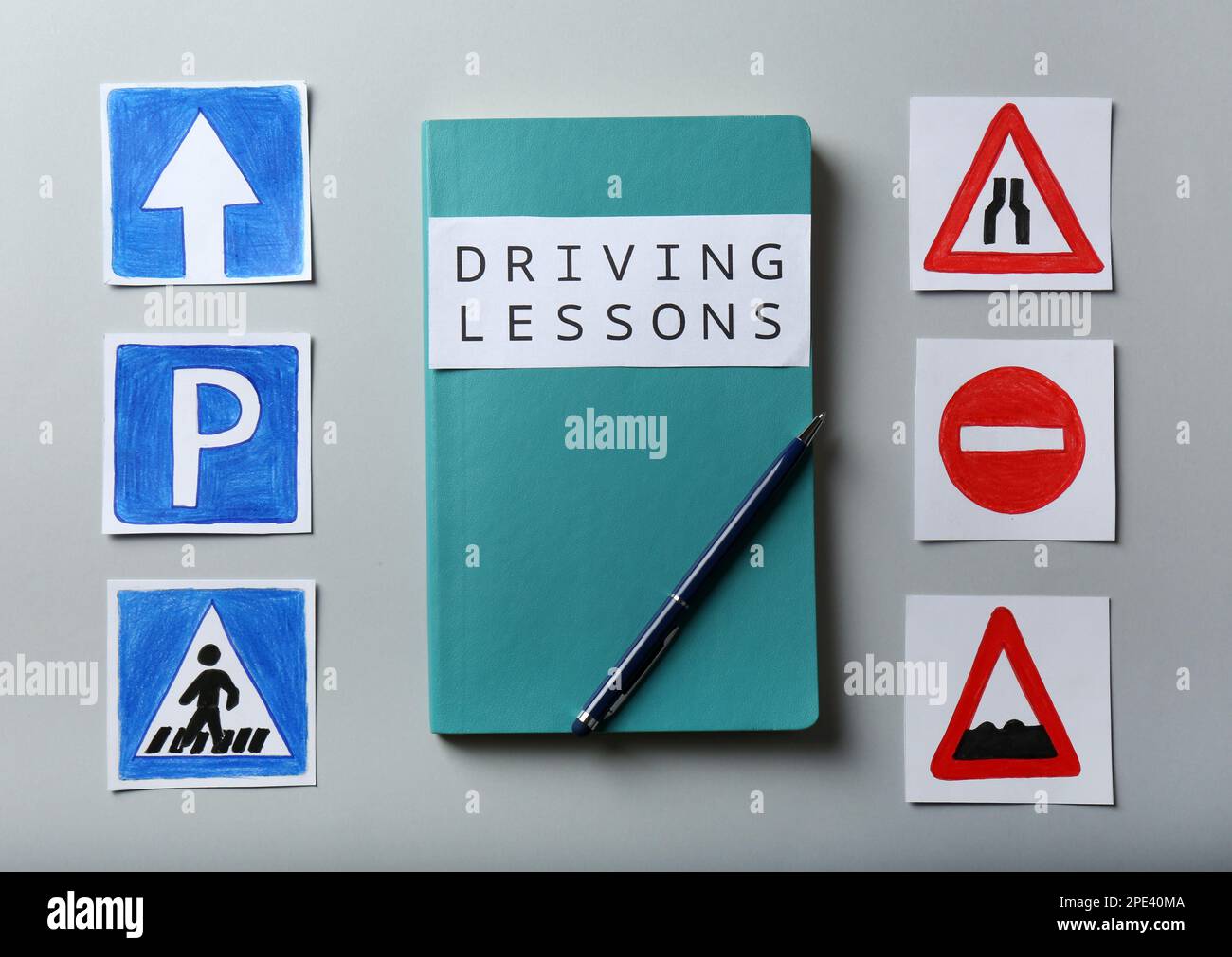 Flat lay composition with workbook for driving lessons and road signs ...