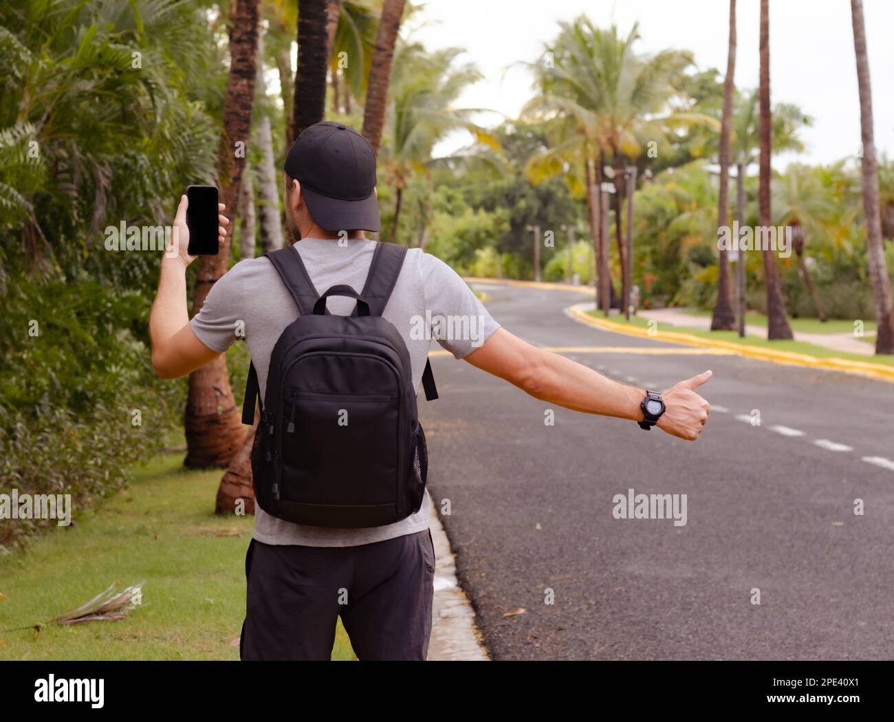 Tourist on road in tropical climate country catching a taxi Stock Photo ...