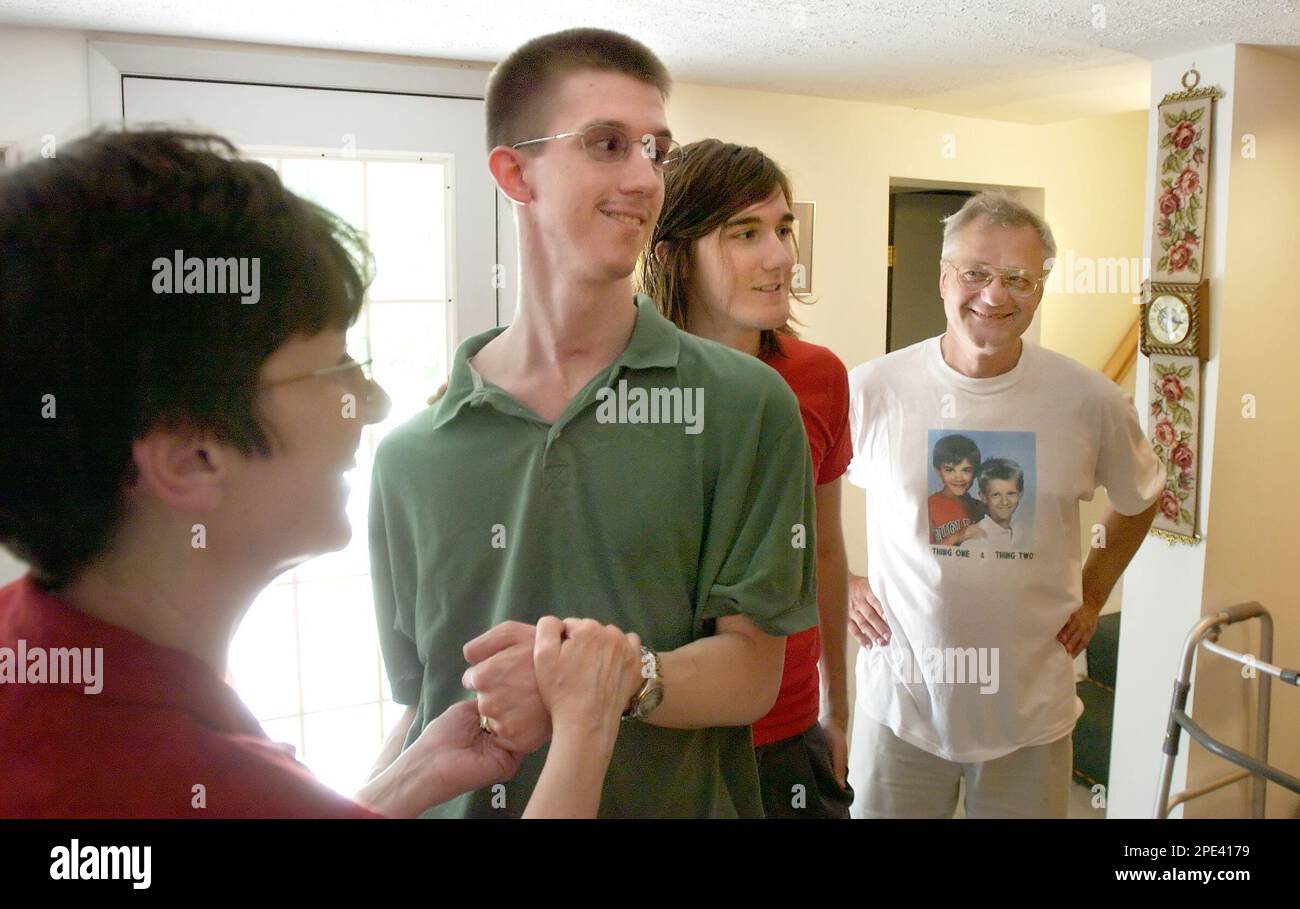 Paul Grois holds hands with his mother, left, while his younger brother Erich and his father ...